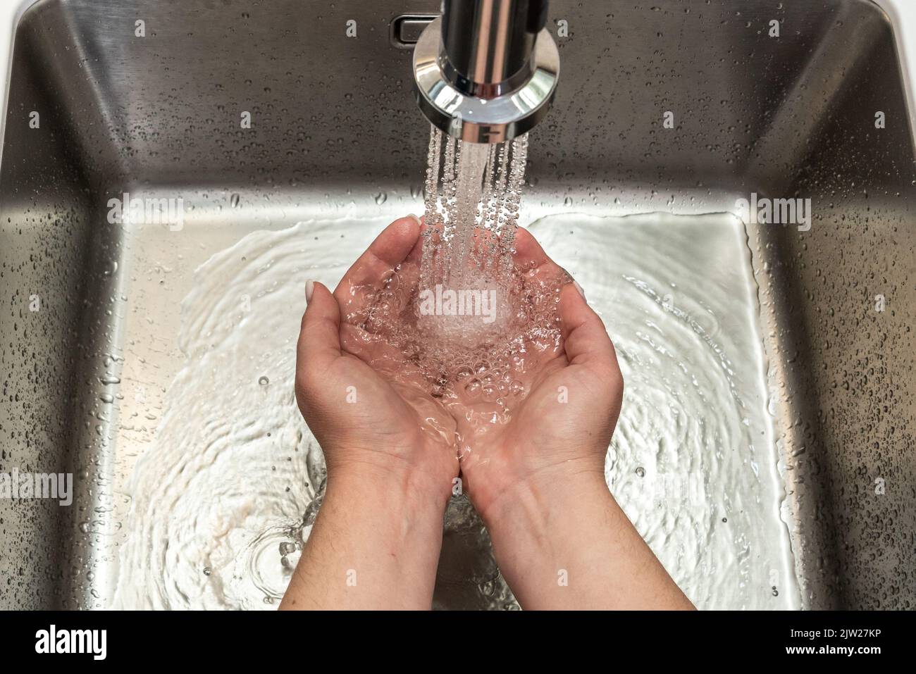 Female hands with palms full of tap water in the kitchen Stock Photo ...