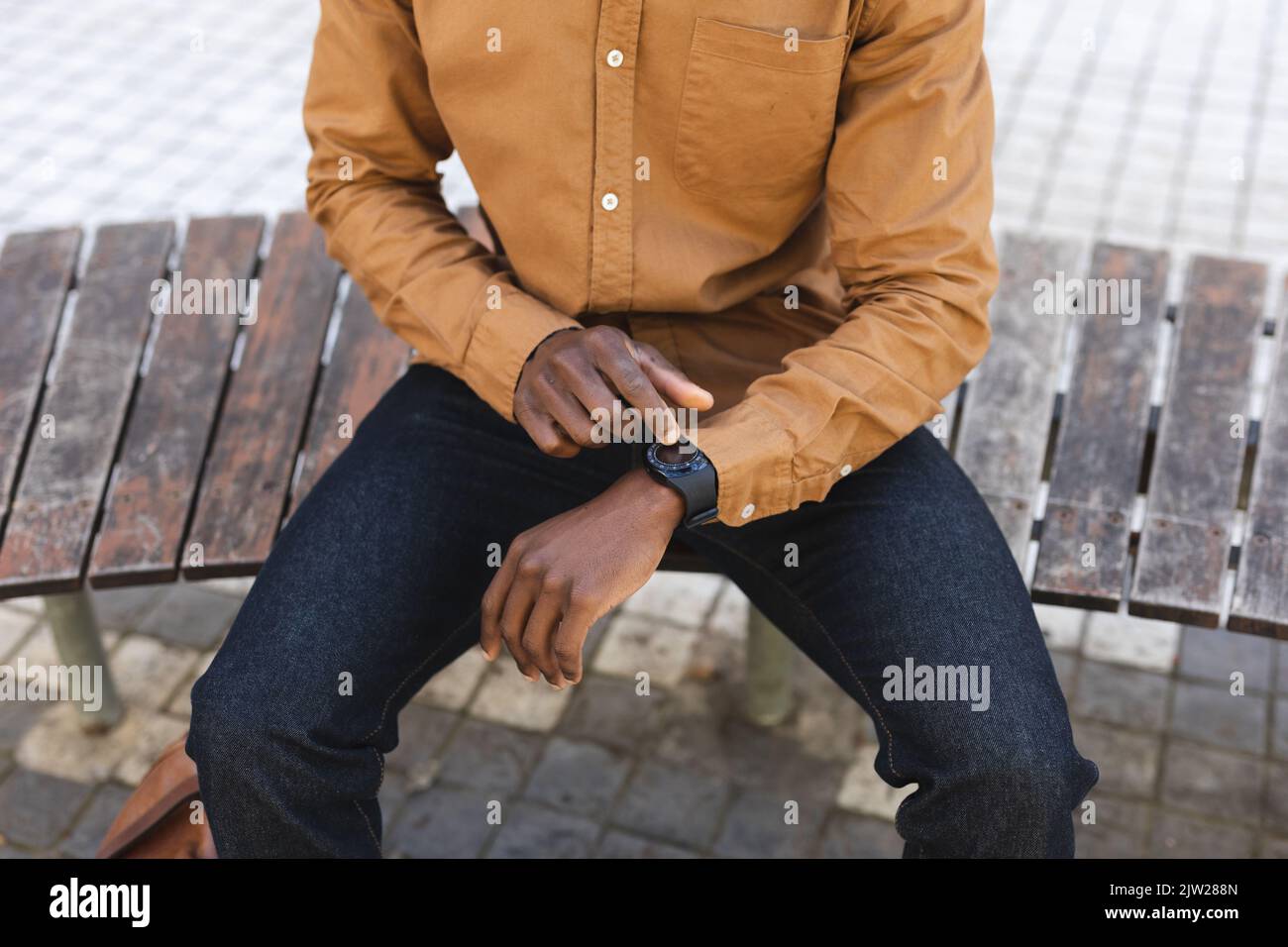 African man using smartwatch sitting hi-res stock photography and ...