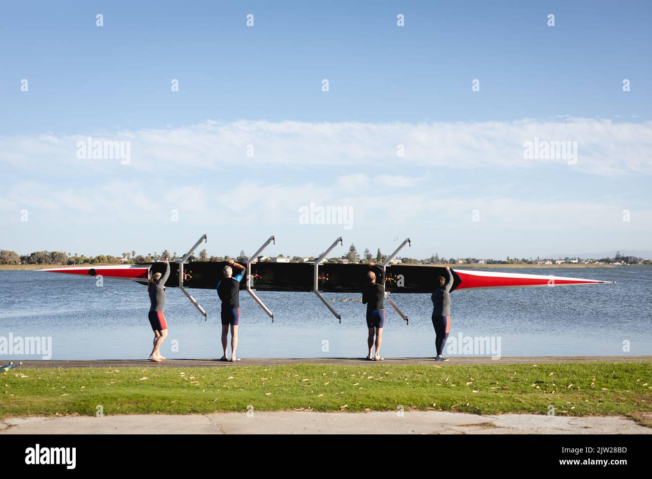 Senior caucasian rowing team putting the boat in the lake while ...