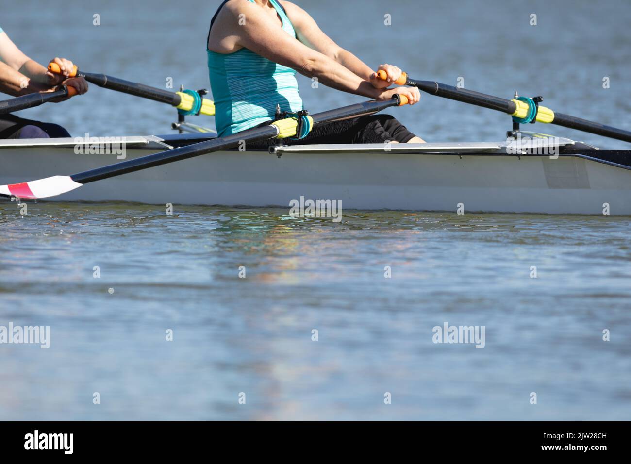 Mid section of two senior caucasian female rowers rowing the boat on ...