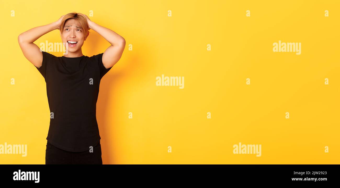 Portrait of young asian guy panicking, looking anxious and upset ...