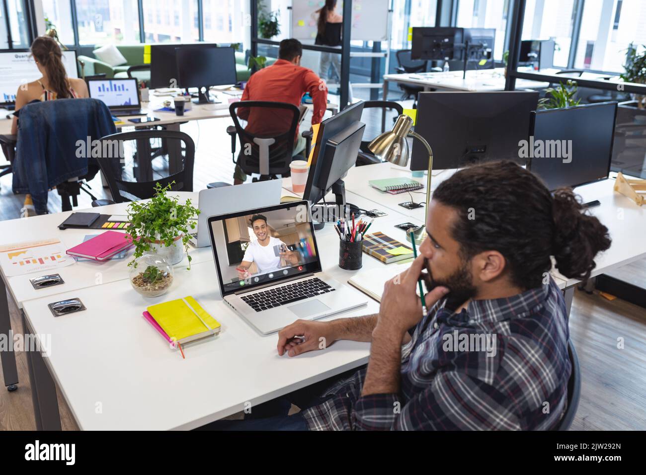 Biracial businessman discussing work with male colleague while video ...
