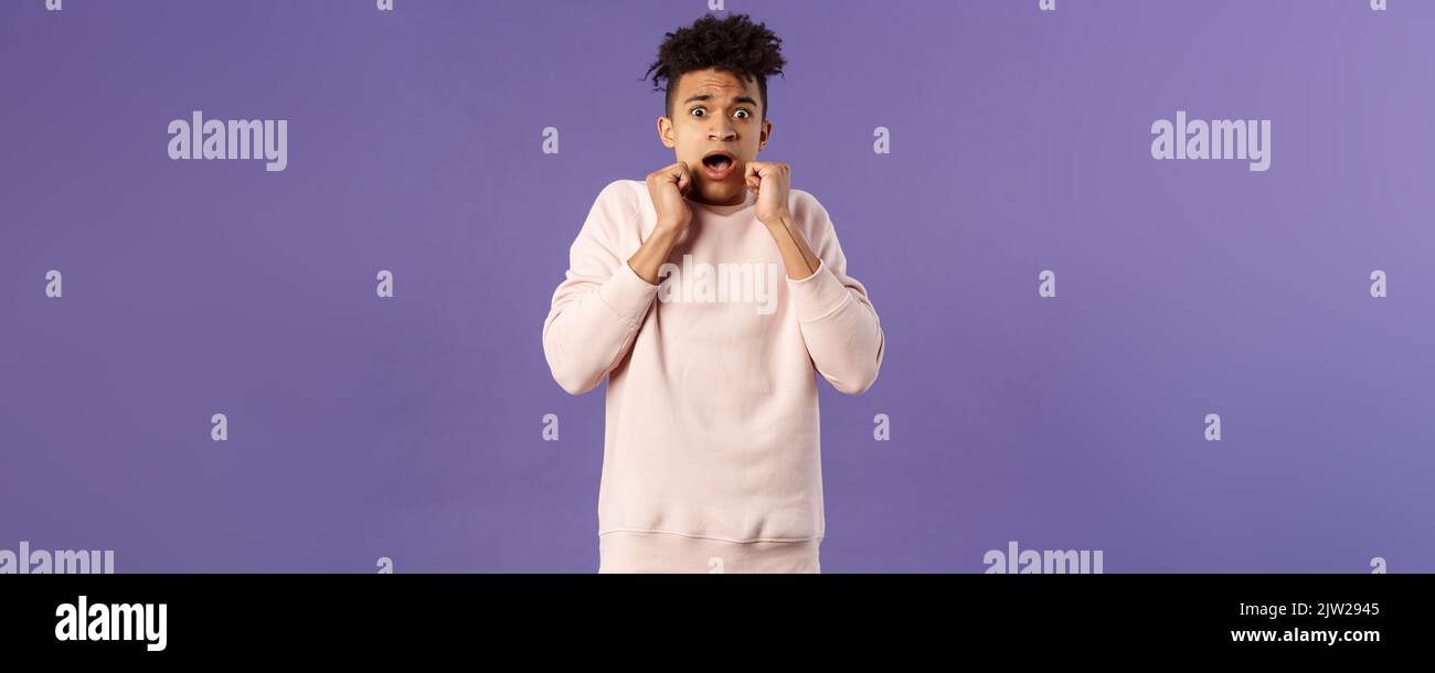 Portrait of scared hispanic guy screaming from fright, hold hands near ...