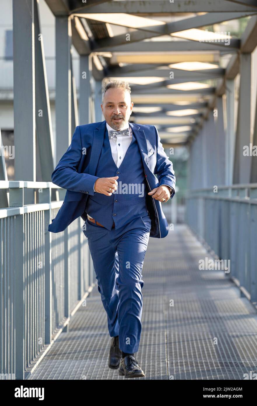 Man in blue suit fleeing over bridge, Rheinhafen, Karlsruhe Stock Photo ...