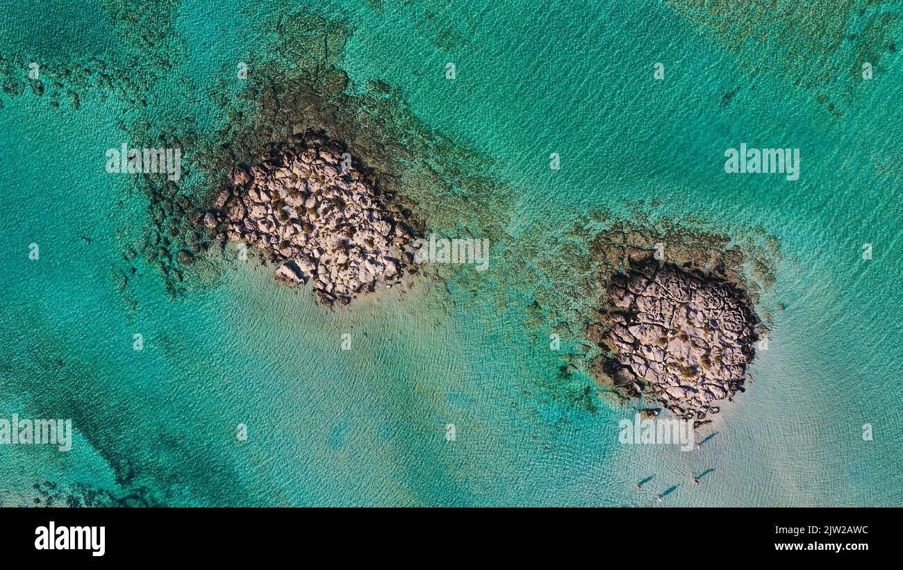 Drone shot, direct from above, detail, two rocky islets, shallow lagoon ...
