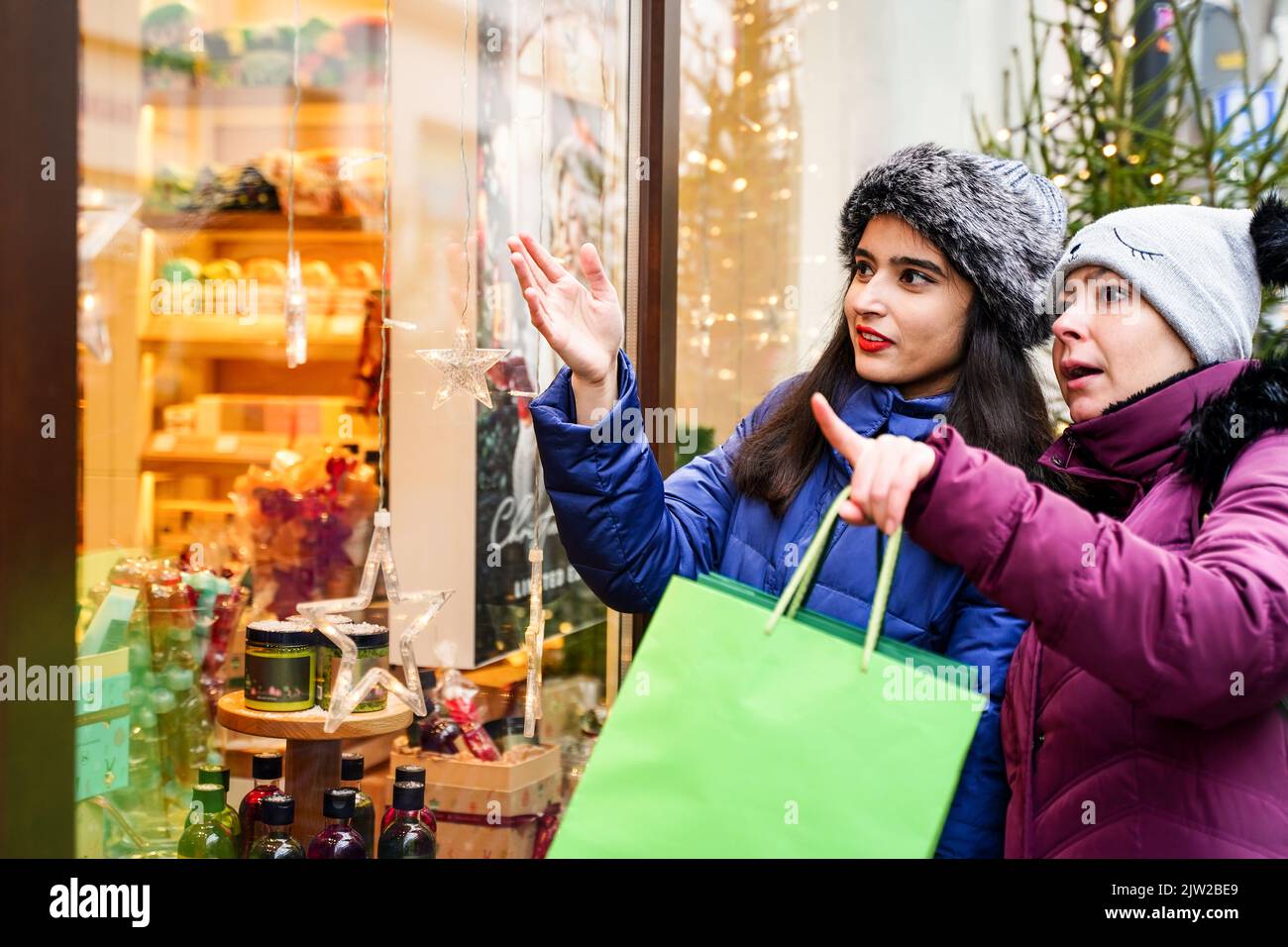 Surprised friends of different nationalities near a shop window. Happy ...