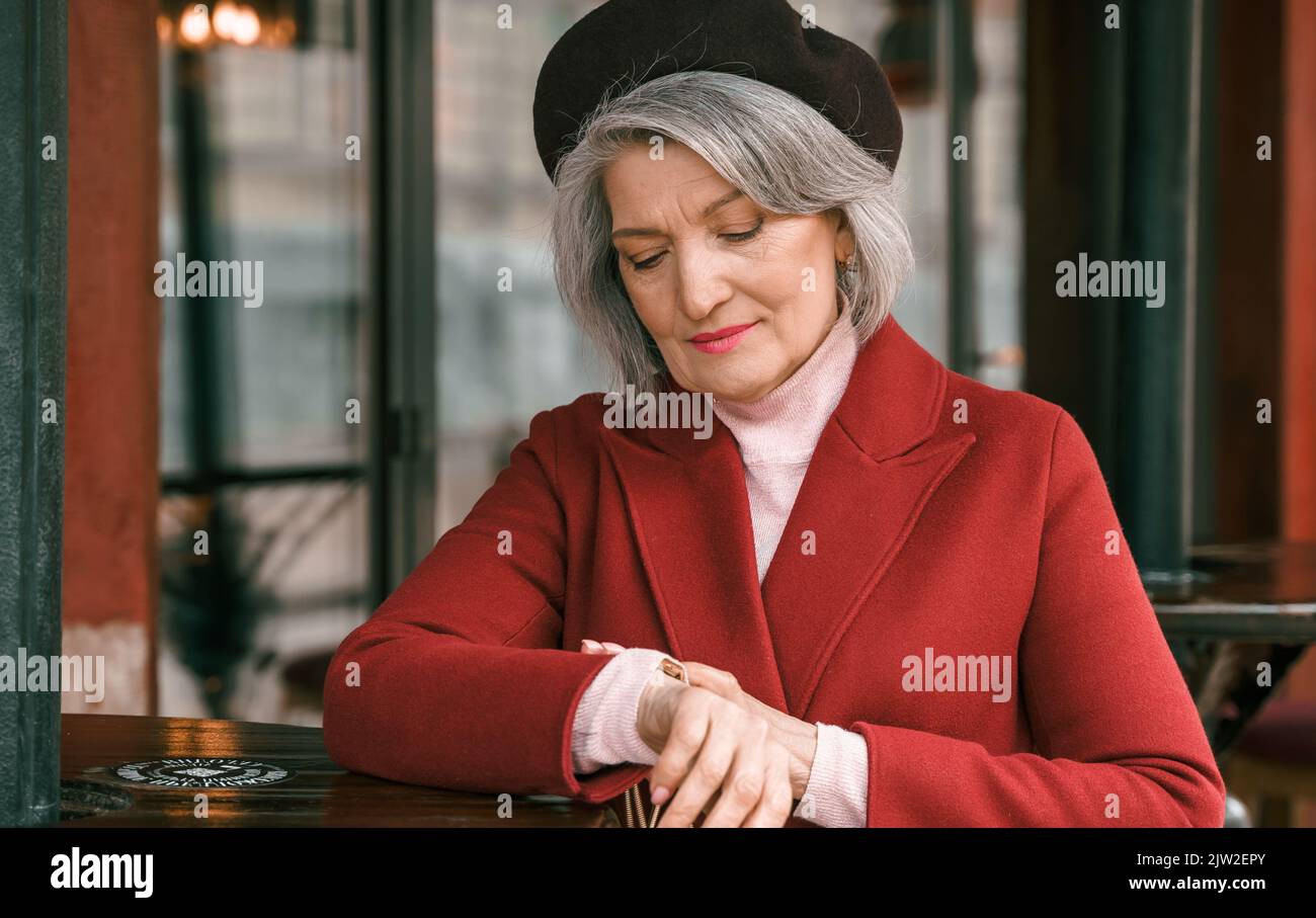 Elderly senior woman walking at cafe table in restaurant. Old retired ...