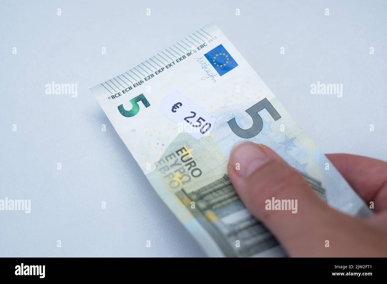 Five euro banknote with 2 euro 5 cent price tag. Selective focus on ...