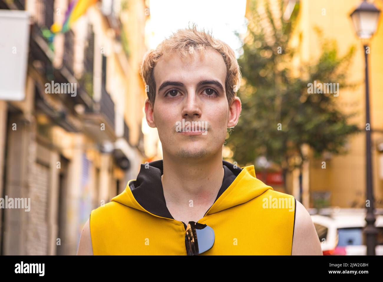 Serious non binary male in stylish clothes looking away on blurred ...