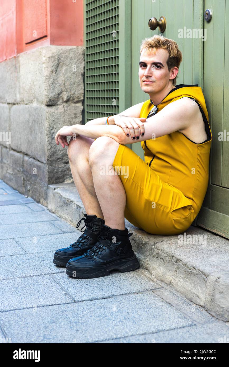 Full body stylish non binary male in yellow jumpsuit and black boots ...