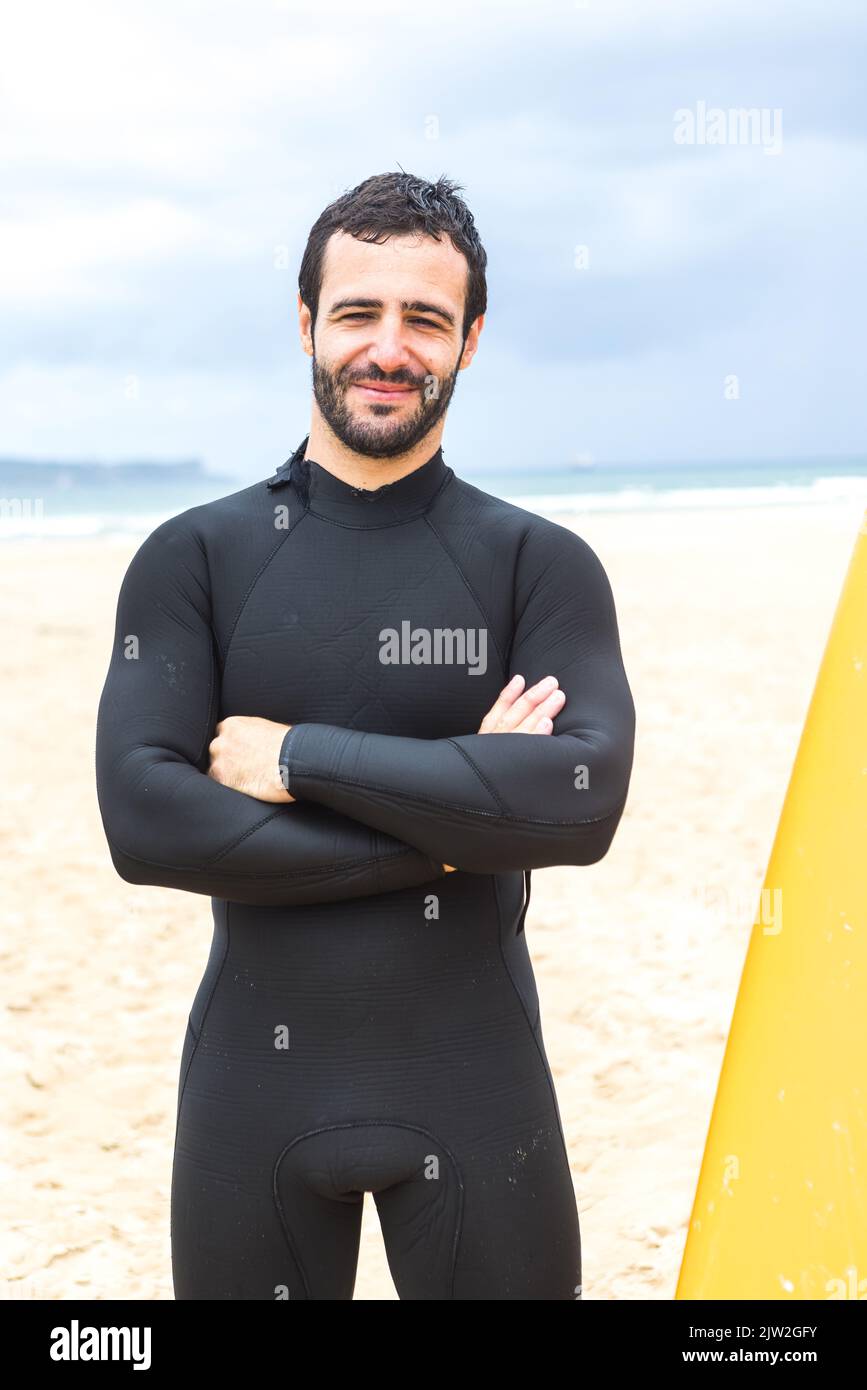 Full body of cheerful young Hispanic male surfer with dark hair and ...