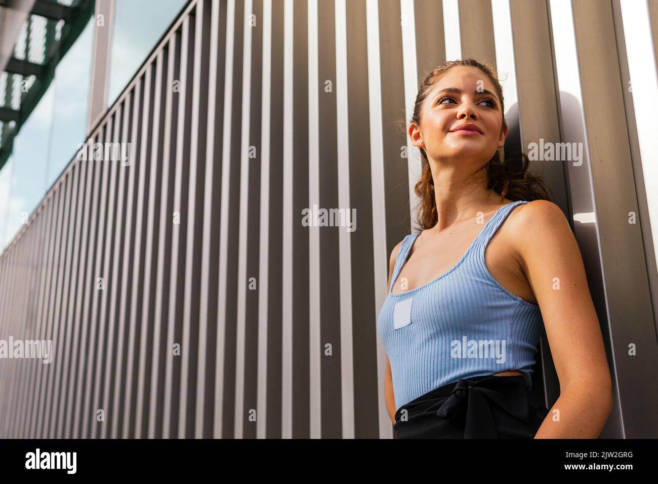 From below self assured young happy female with long brown wavy hair in ...
