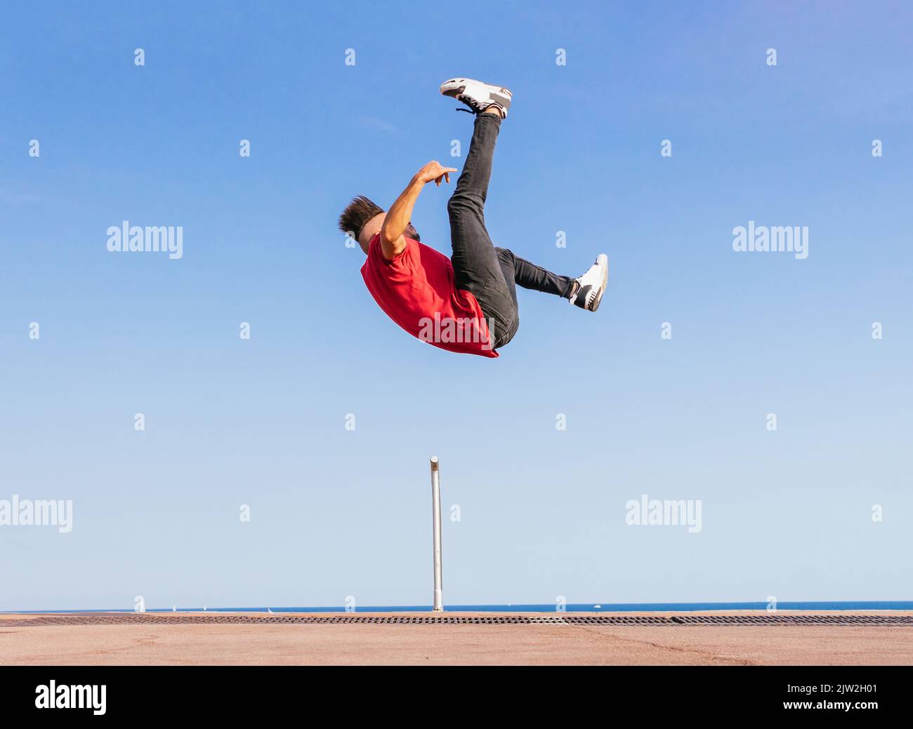 Male jumping from edge of building and showing somersault while doing ...