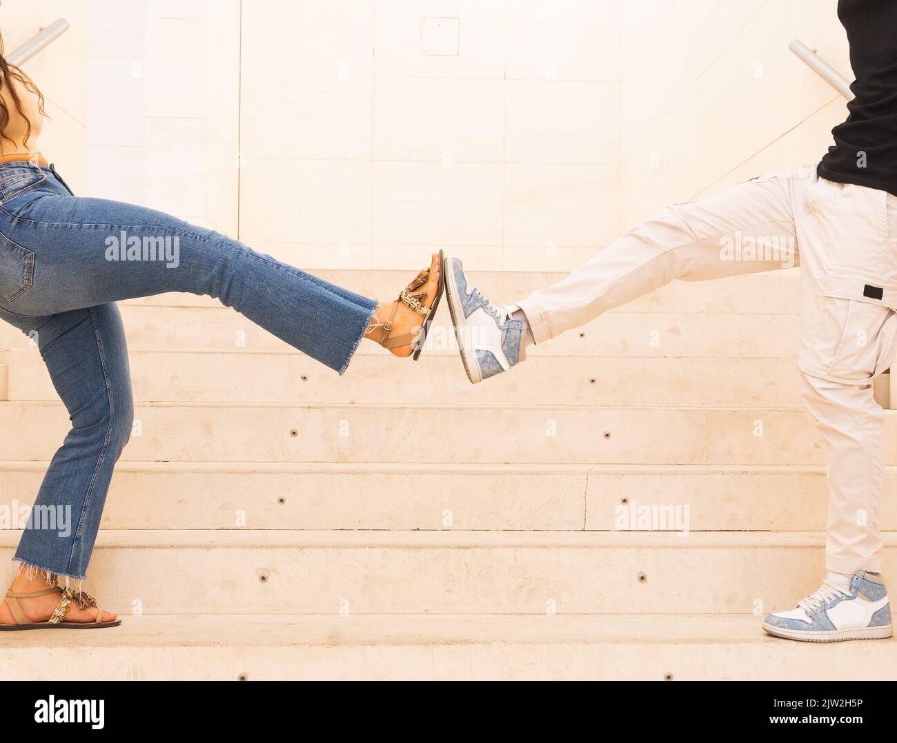 Anonymous young couple touching toes while standing on steps in ...