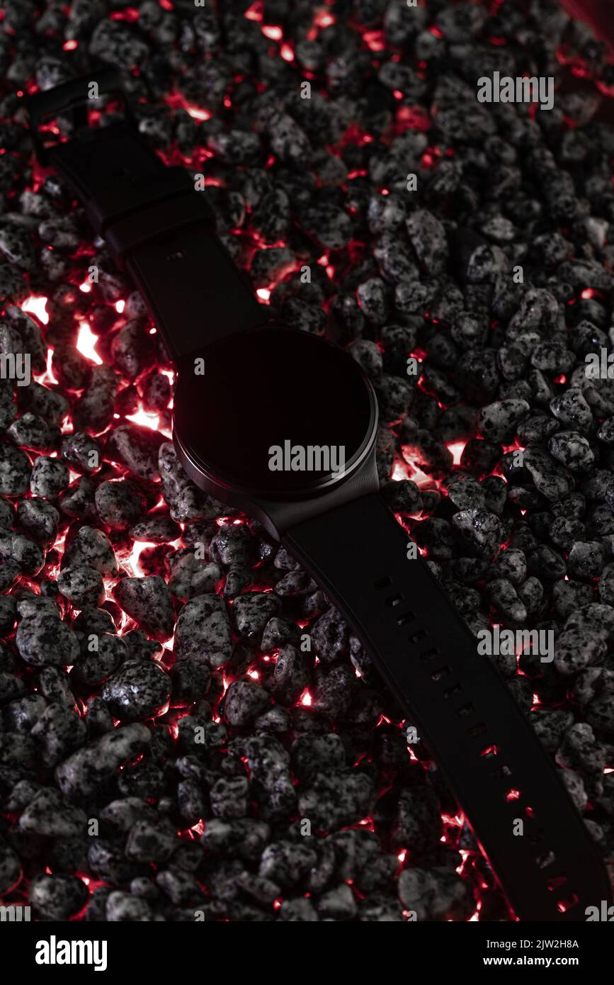 From above modern smart watch with black screen lying on rocks ...