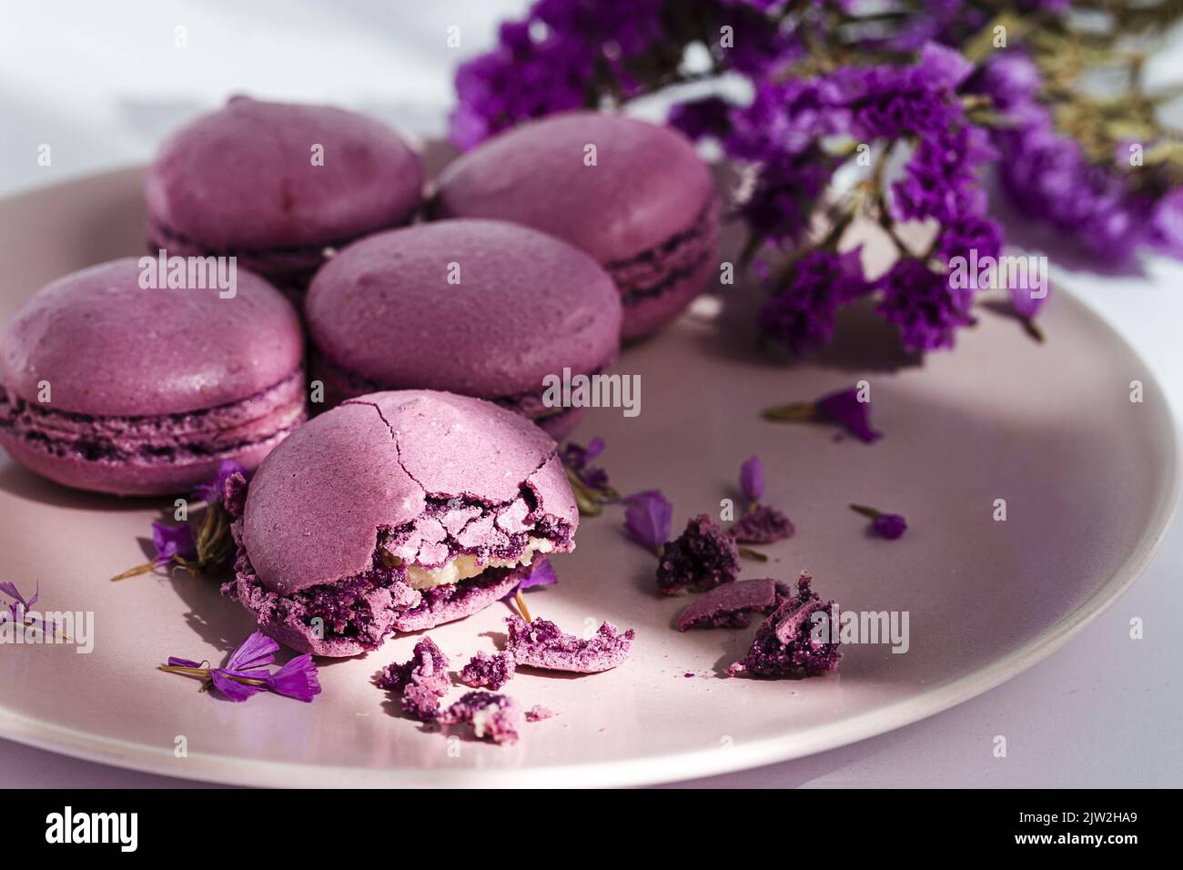 Bunch of delicious violet macaroons served on plate near delicate ...
