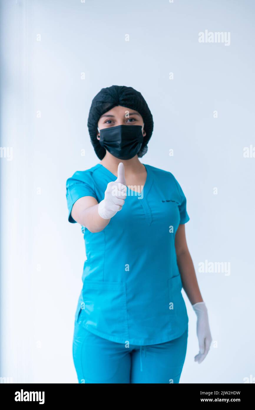 Content young female medic in blue scrubs protective gloves mask cap ...