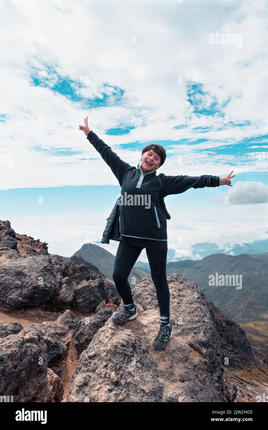 Full body of carefree female hiker with backpack standing with ...