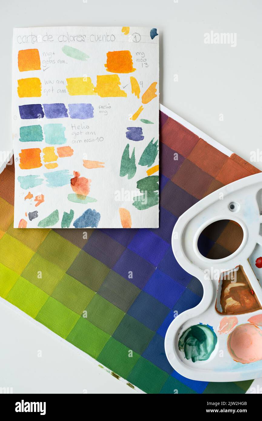 Top view of plastic palette with paint and paper sheets with color ...