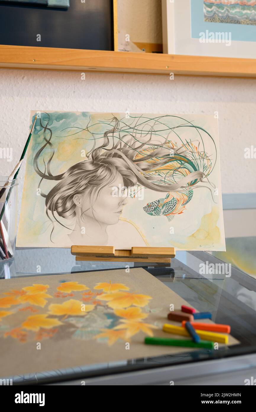 Paper sheets with creative illustrations placed on table in light ...
