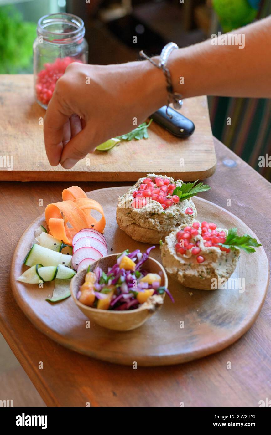 High angle of crop faceless cook sprinkling fresh vegetable salad with ...