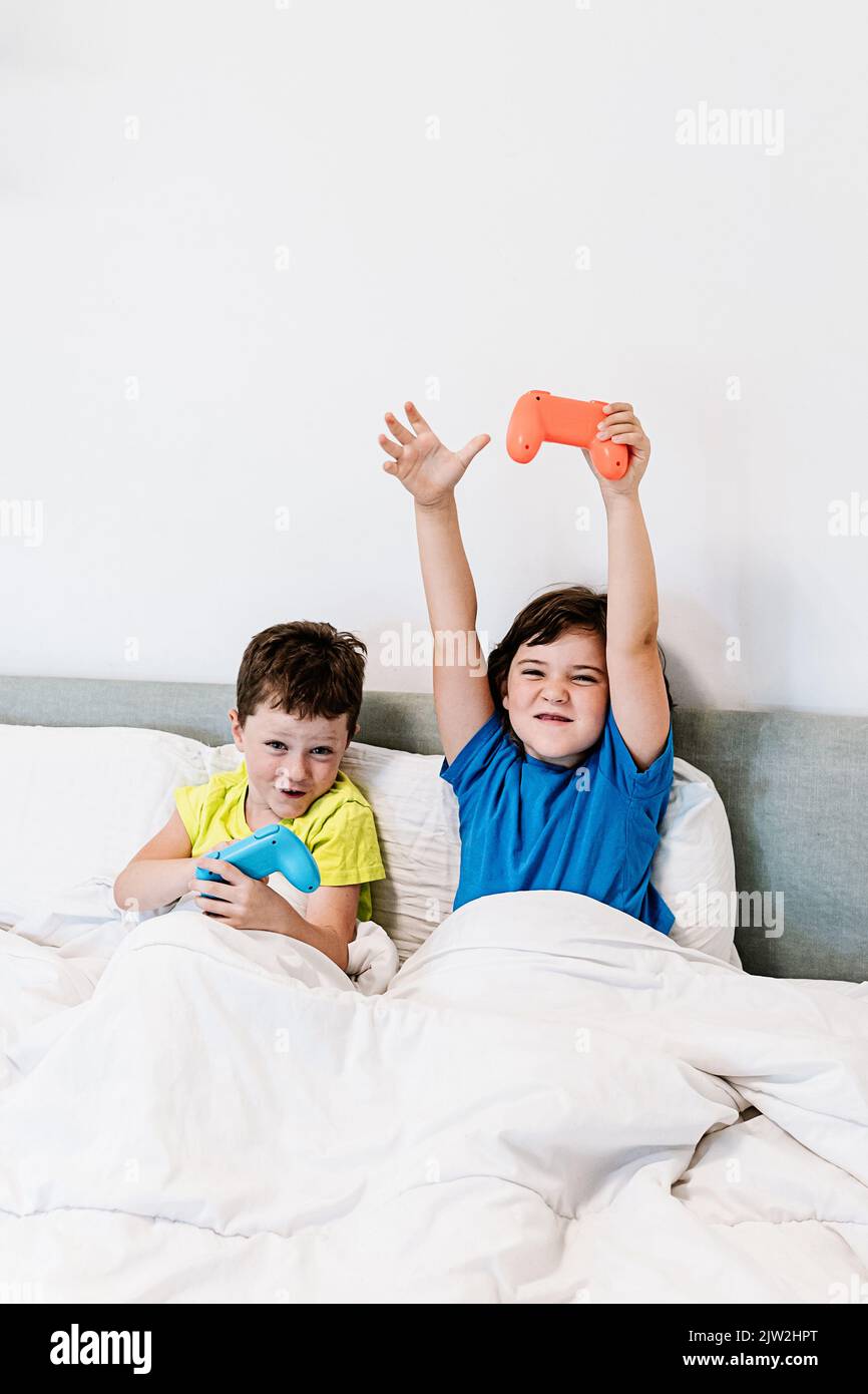 Content gil raising arm with game pad in excitement while playing with ...