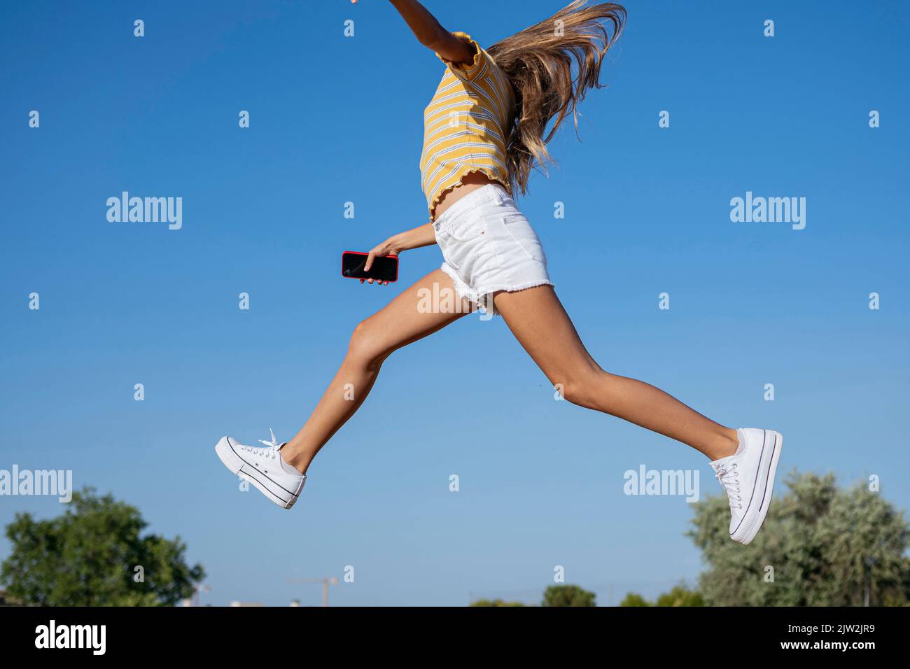 Full body side view of unrecognizable active delighted teenage girl ...