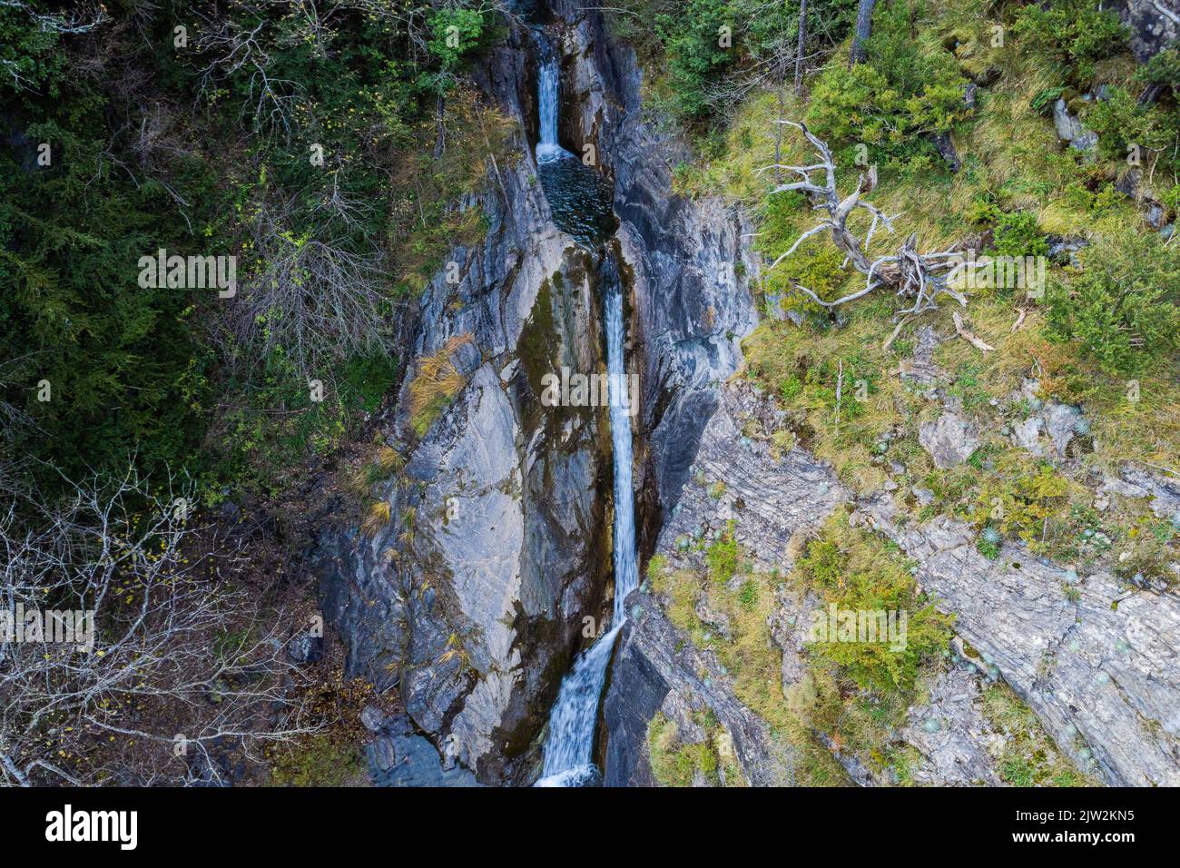 Clean water falling from rough rocky cliff and forming rapid stream in ...