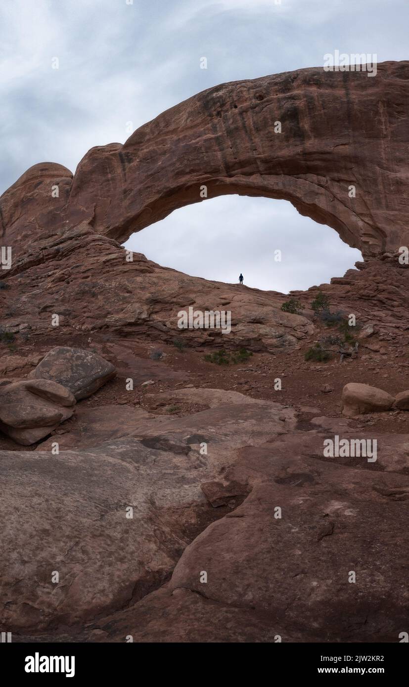 Tourist admiring breathtaking low angle view of natural stone formation ...