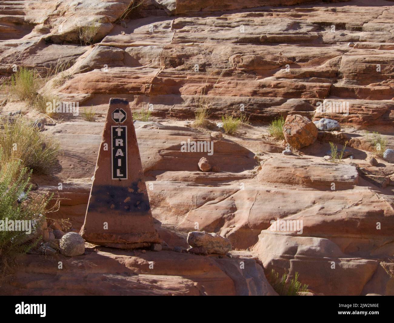 An arrow and trail text on a rock in a hiking area Stock Photo - Alamy