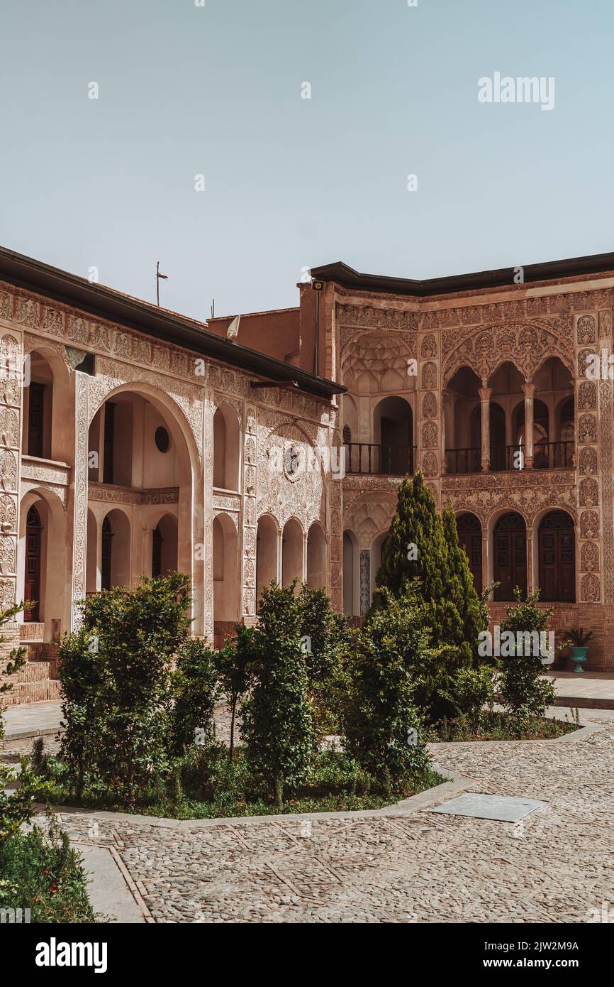 Green plants growing near ancient house with arched windows and ...