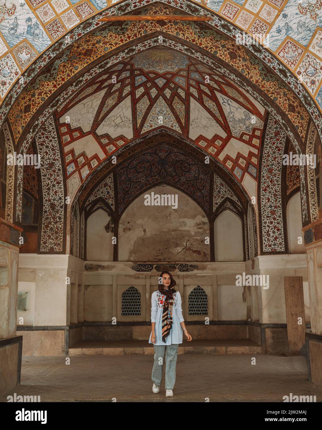 Full body of female standing in traditional mosque with ornamental ...