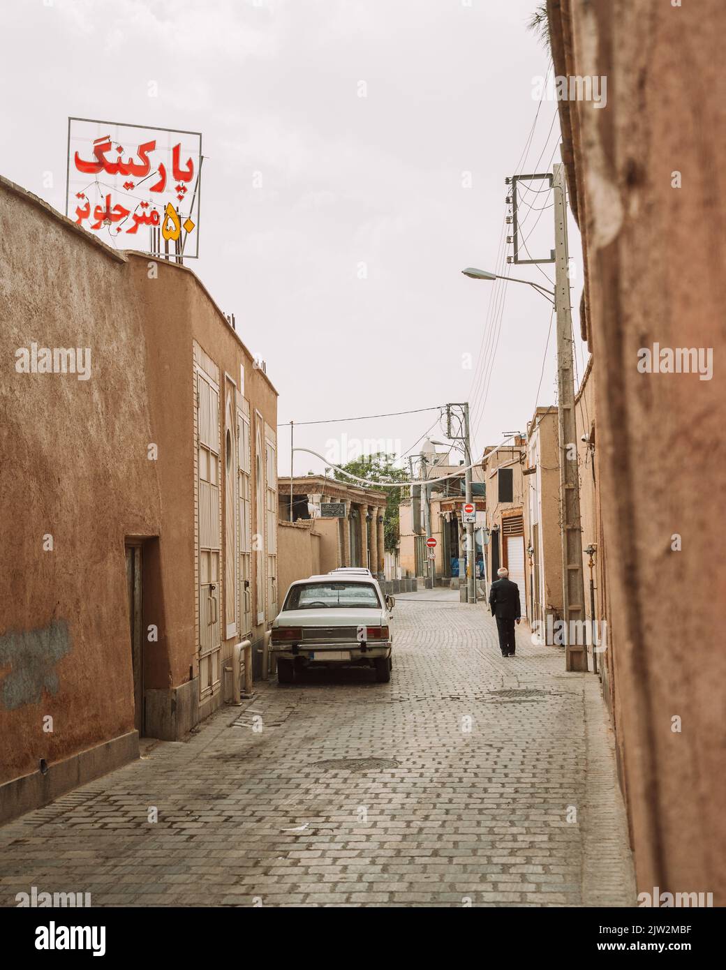 Narrow paved street with parked automobile and sign Parking 10 Meters ...