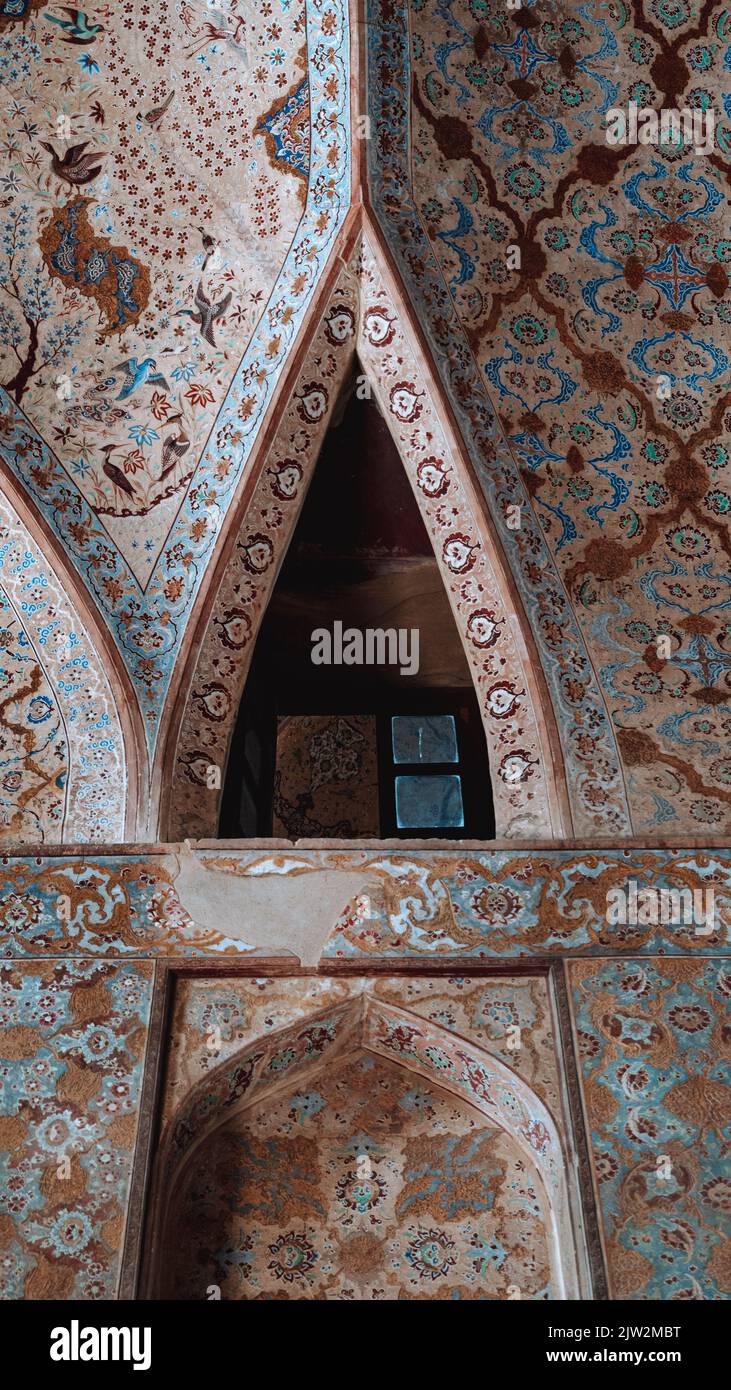 From below of arched window decorated with ornamental mosaic in wall of ...