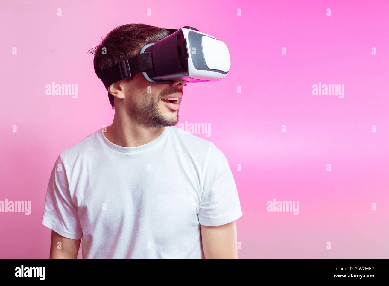 Positive male gamer in modern VR headset celebrating victory while ...