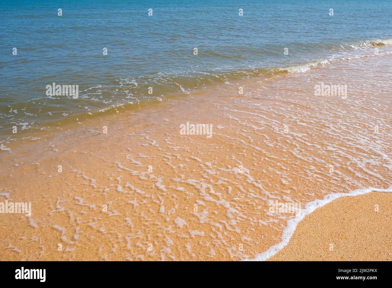 The coast of the Sea of Azov. Sea waves roll on the sandy shore ...