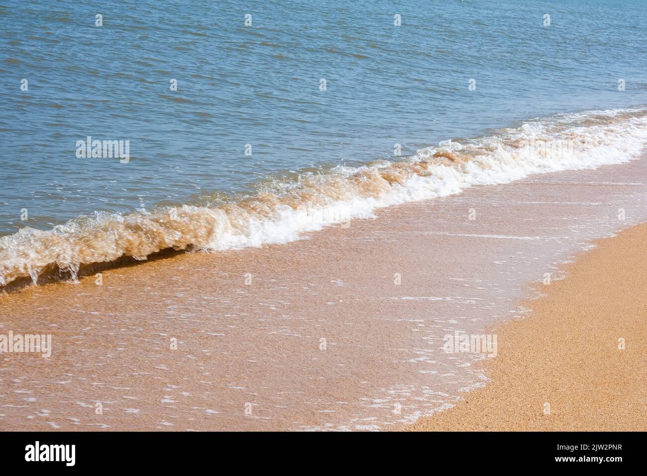 The coast of the Sea of Azov. Sea waves roll on the sandy shore ...