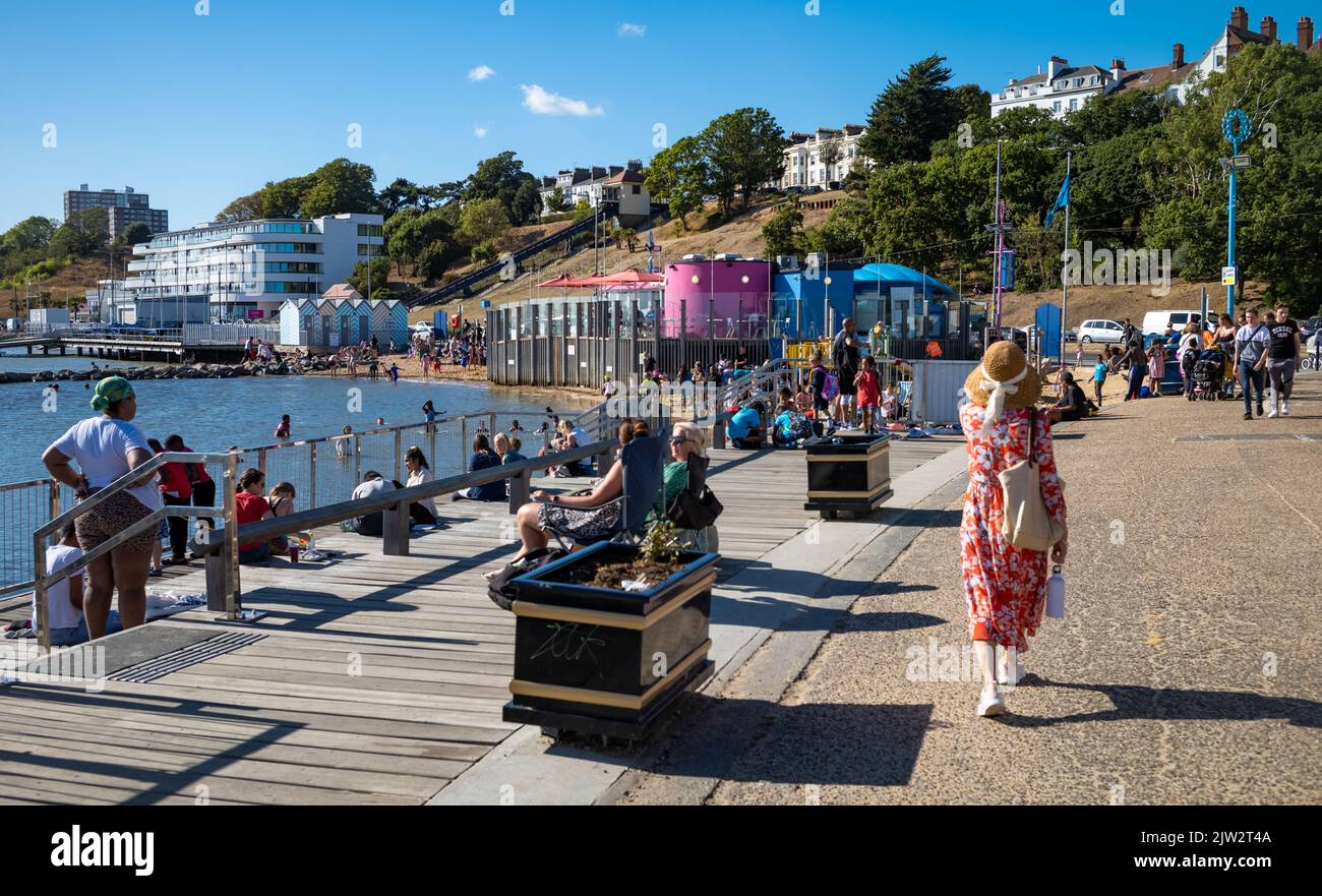 People sit in the sun at the edge of Three Shells Lagoon on the ...