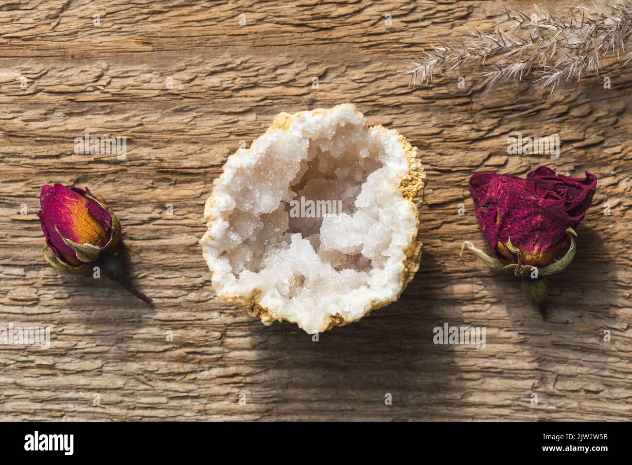 Quartz in Geode mineral stone with dry roses on wooden background Stock ...