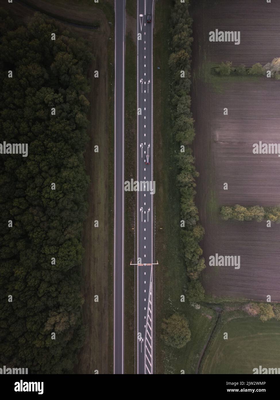 A top-down drone shot of a road with forest on one side Stock Photo - Alamy