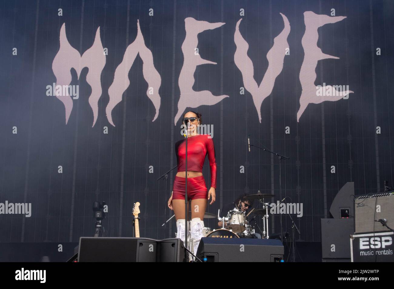 Maeve singing wearing a red top and shorts Stock Photo - Alamy