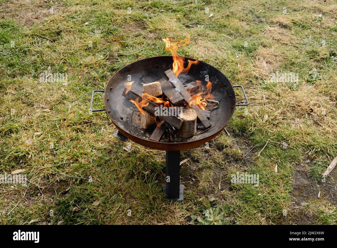 A fire pit on a farm lit with a small fire and eco recycled wood you ...