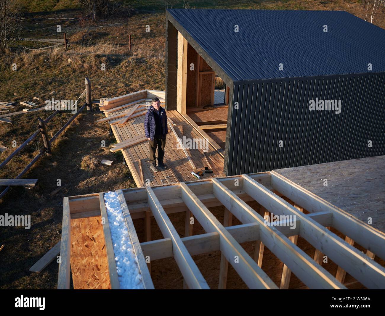Male architect building wooden frame house in the Scandinavian style ...