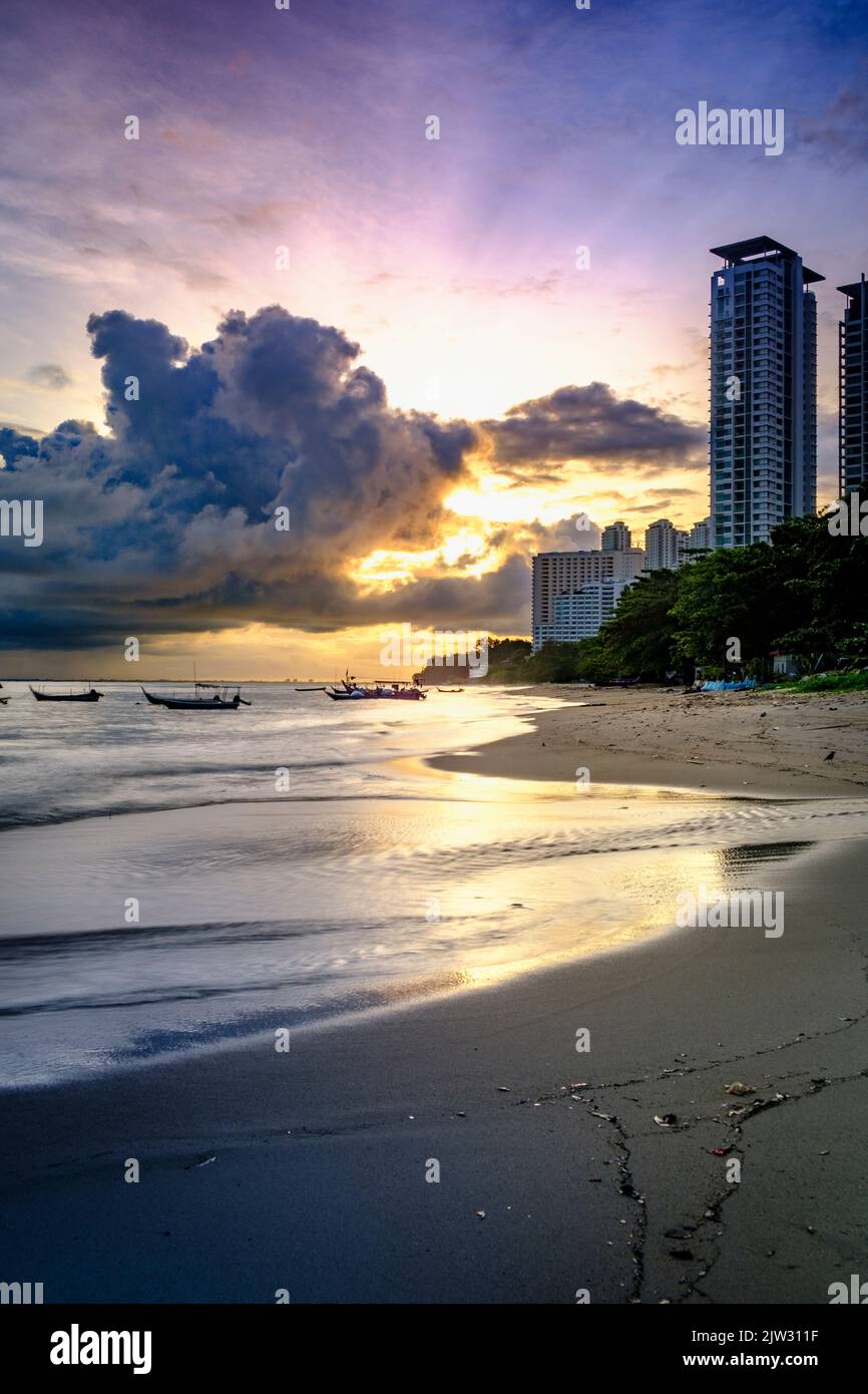 Sunrise from behind the clouds producing vibrant colors and lighting at ...
