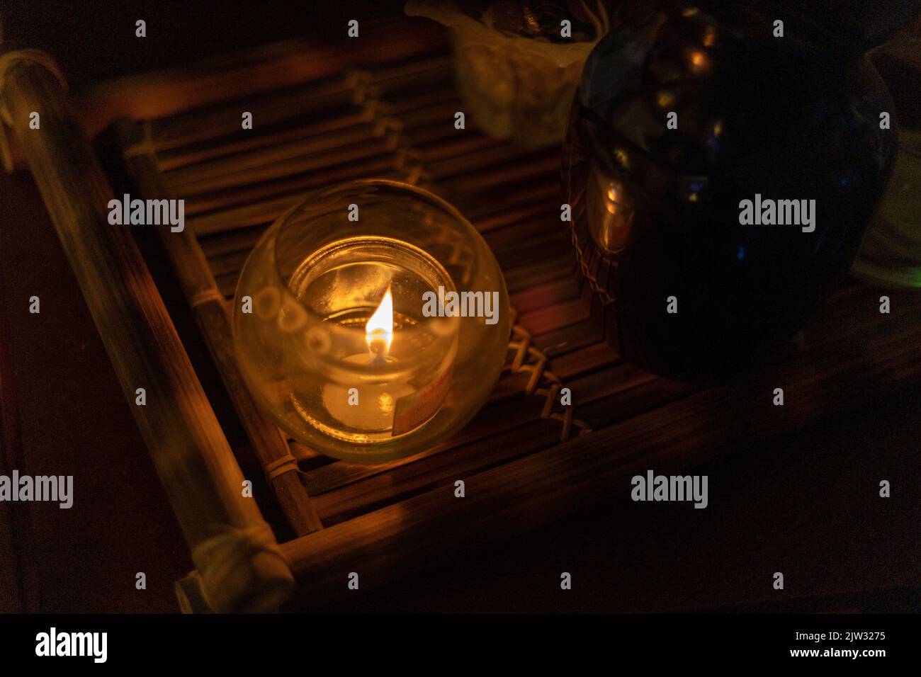 A top closeup of glass candlelight on the dinner table with dark ...