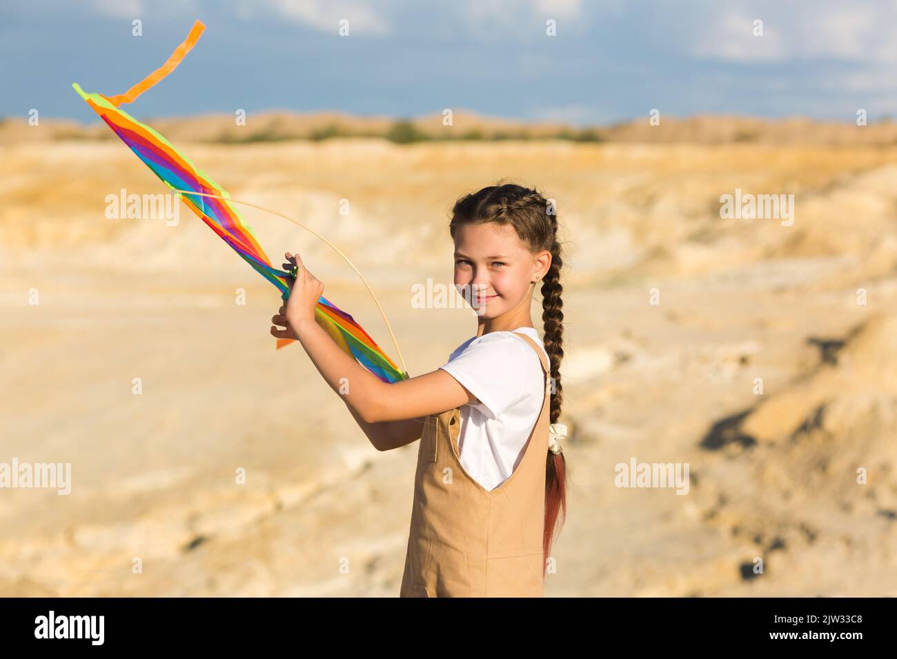 Girl with a kite in her hands on the background of mountains and desert ...
