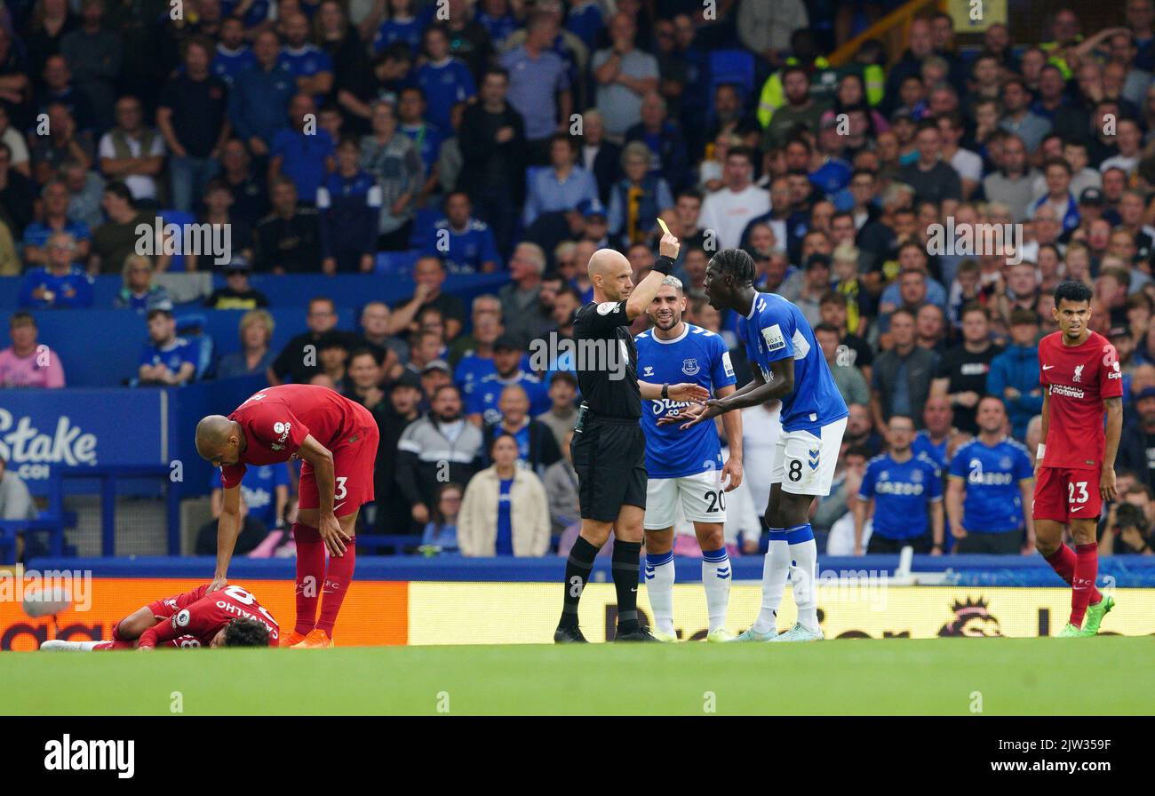 Referee Anthony Taylor shows a yellow card to Everton's Amadou Onana ...