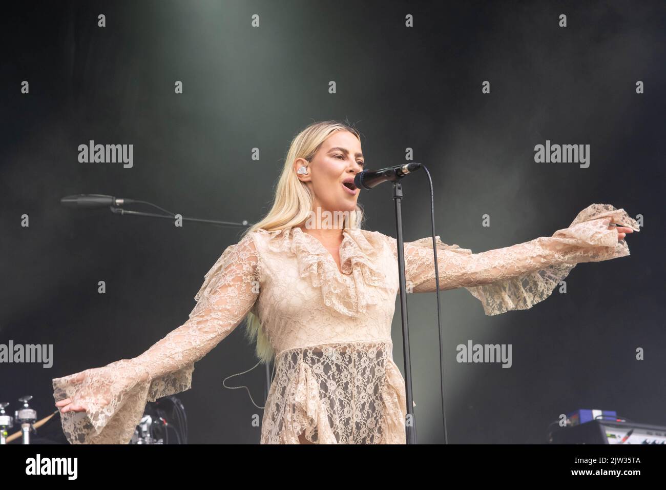 Lyra - singing to the connect audience wearing a lace thrilled blouse ...