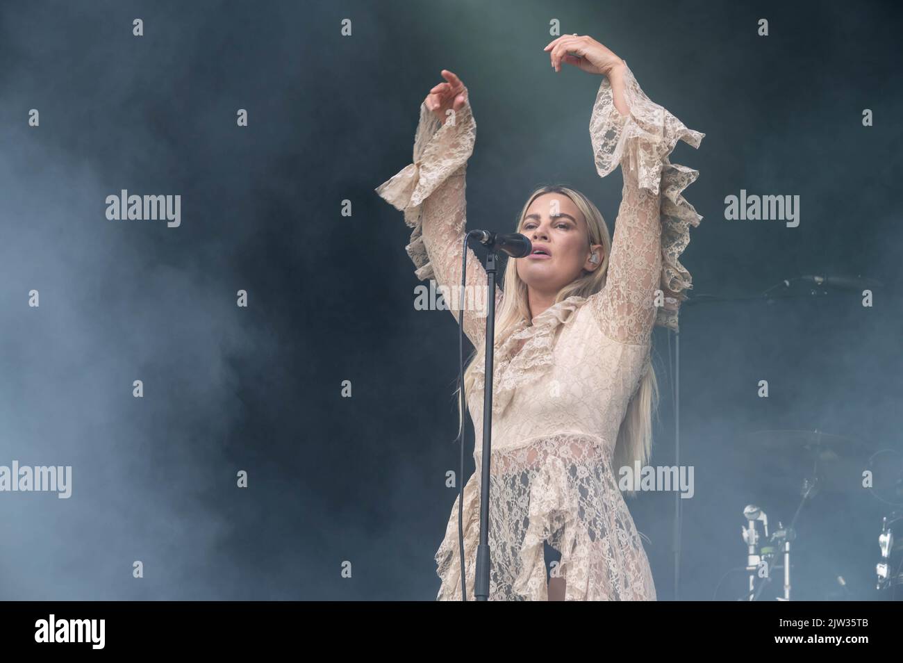 Lyra - singing to the connect audience wearing a lace thrilled blouse ...