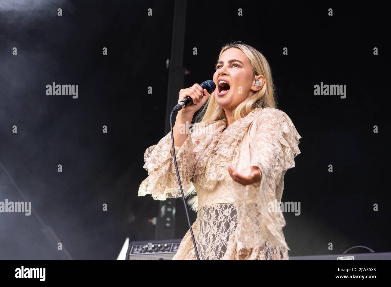 Lyra - singing to the connect audience wearing a lace thrilled blouse ...